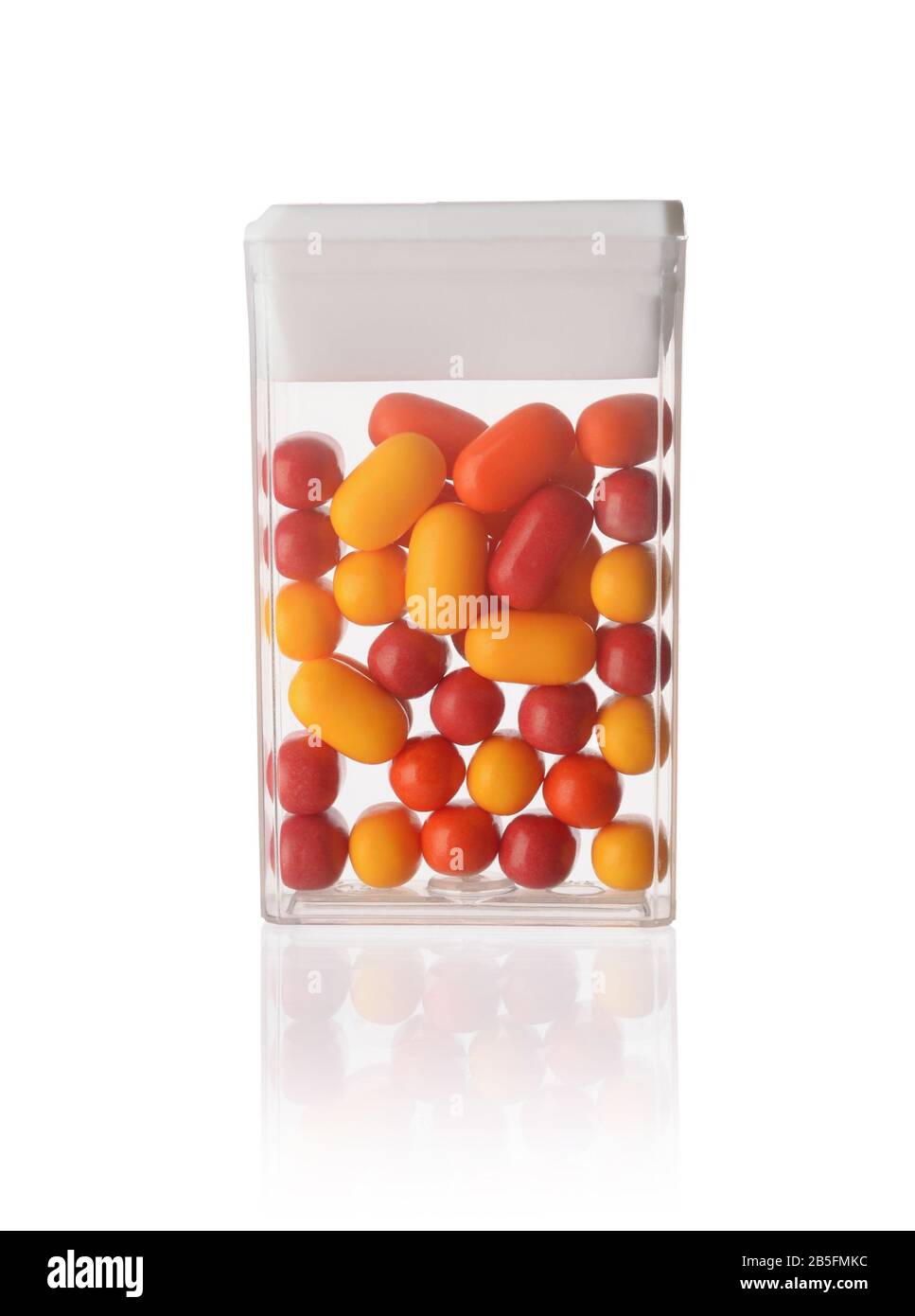 Multi-colored sweets in a plastic container isolated on white ...