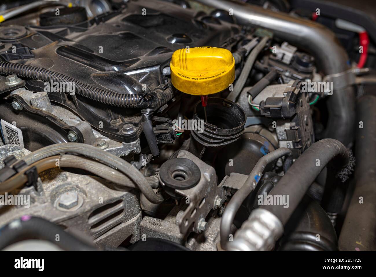 Engine compartment in used car visible open oil filler in yellow and ...