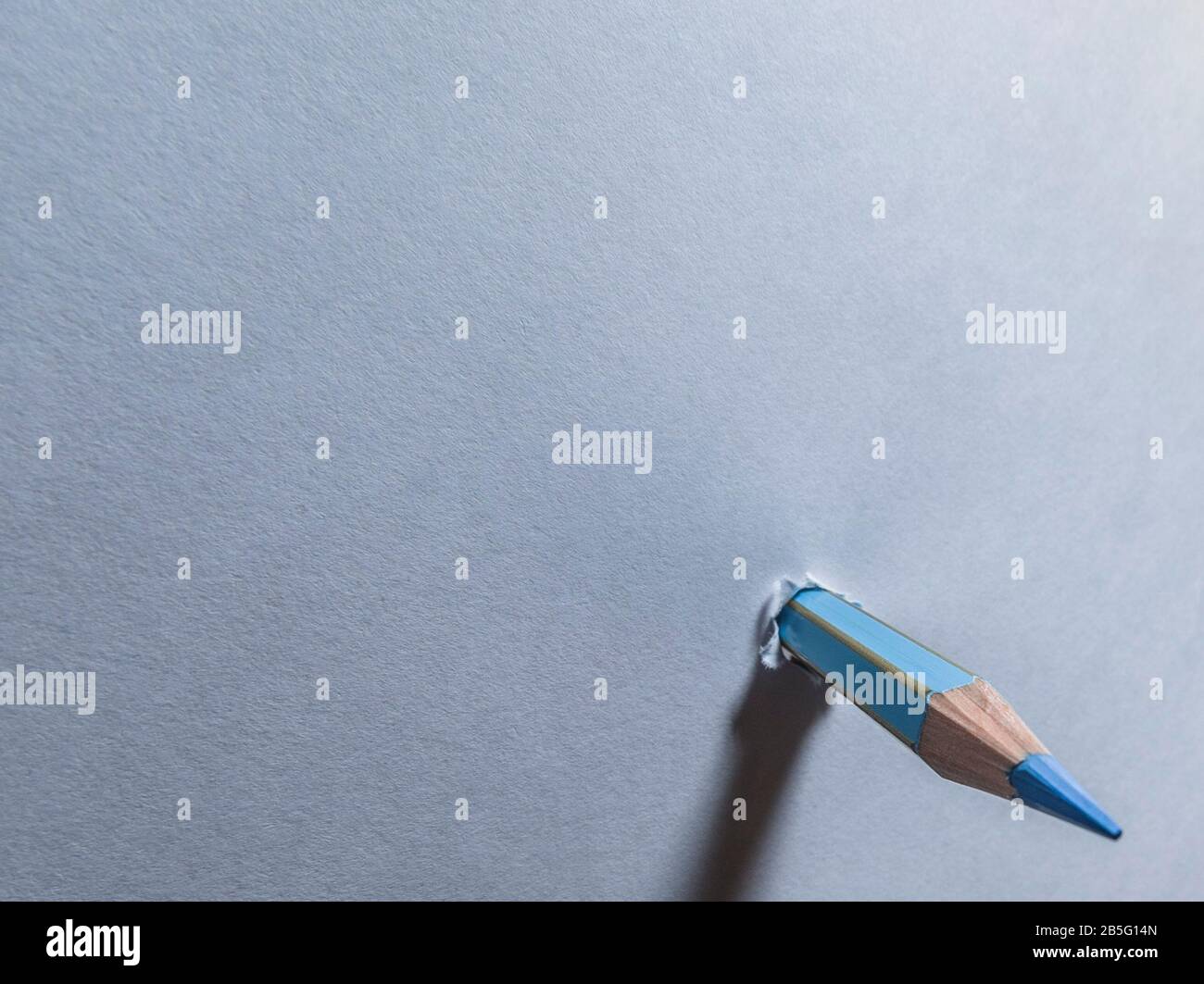 Pencil punching a sheet of paper Stock Photo - Alamy