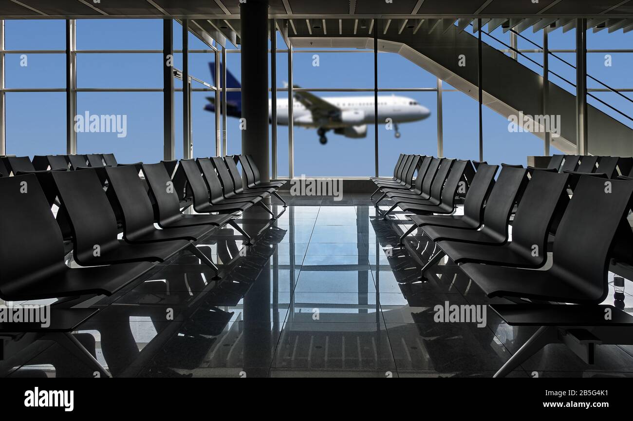Rows of black chairs at airport and plane landing, There is a path for ...