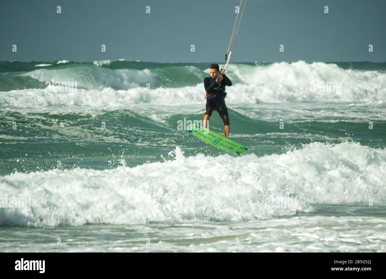 Kite surfer jumping over waves in rough seas at Lacanau-Océan, France ...