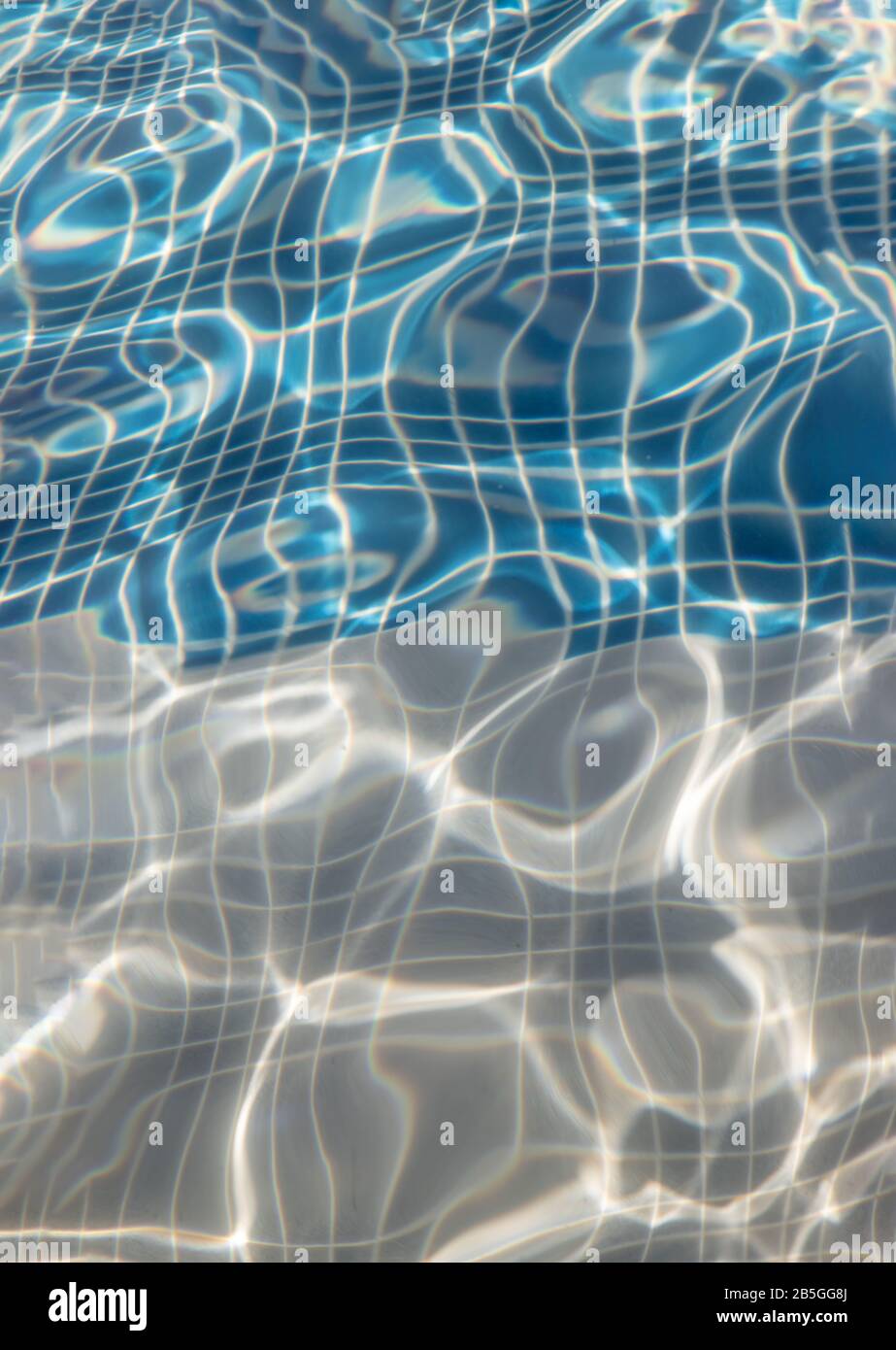 Sun reflection on the blue clear water ripples of swimming pool with ...