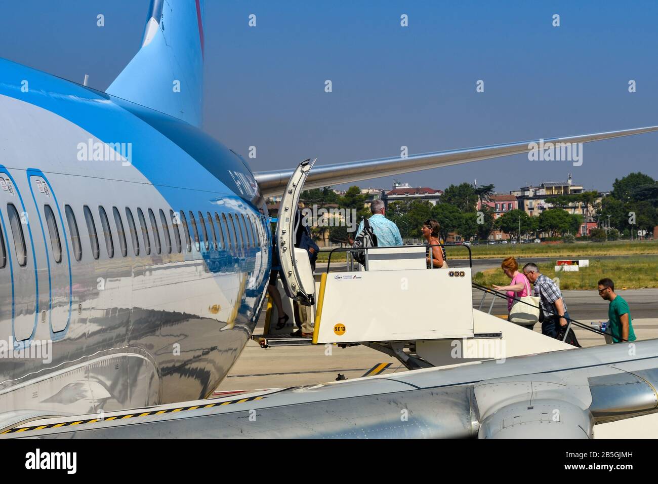 NAPLES, ITALY - AUGUST 2019: Passengers boarding through the rear door ...