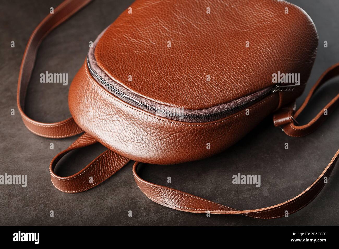 Brown backpack made of textured brown leather on a black stone ...