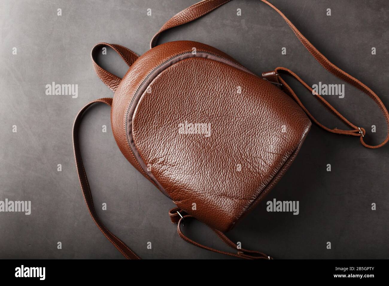 Brown backpack made of textured brown leather on a black stone ...
