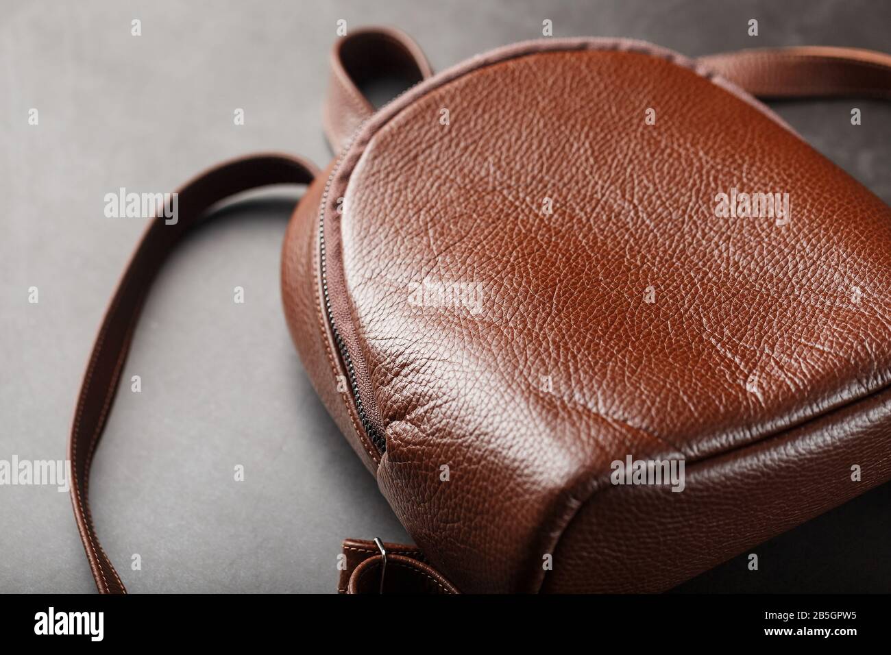 Brown backpack made of textured brown leather on a black stone ...