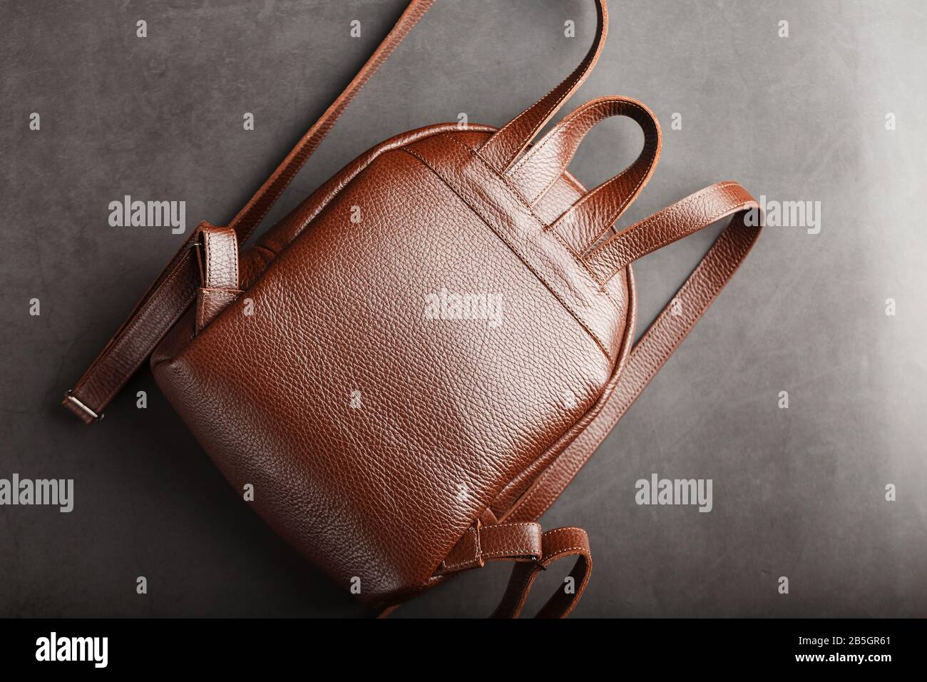 Brown backpack made of textured brown leather on a black stone ...