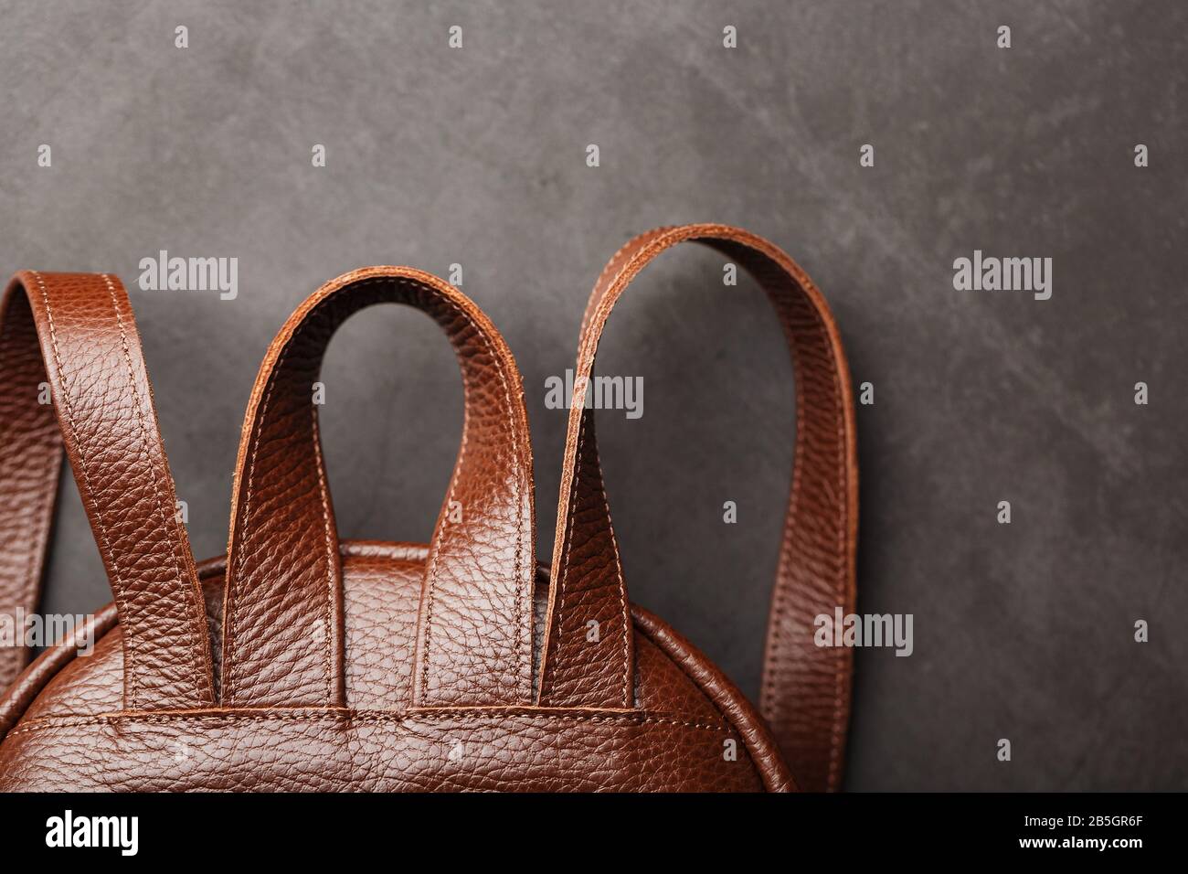 Brown backpack made of textured brown leather on a black stone ...