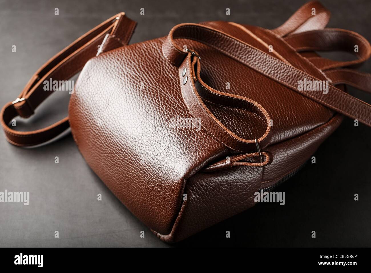 Brown backpack made of textured brown leather on a black stone ...