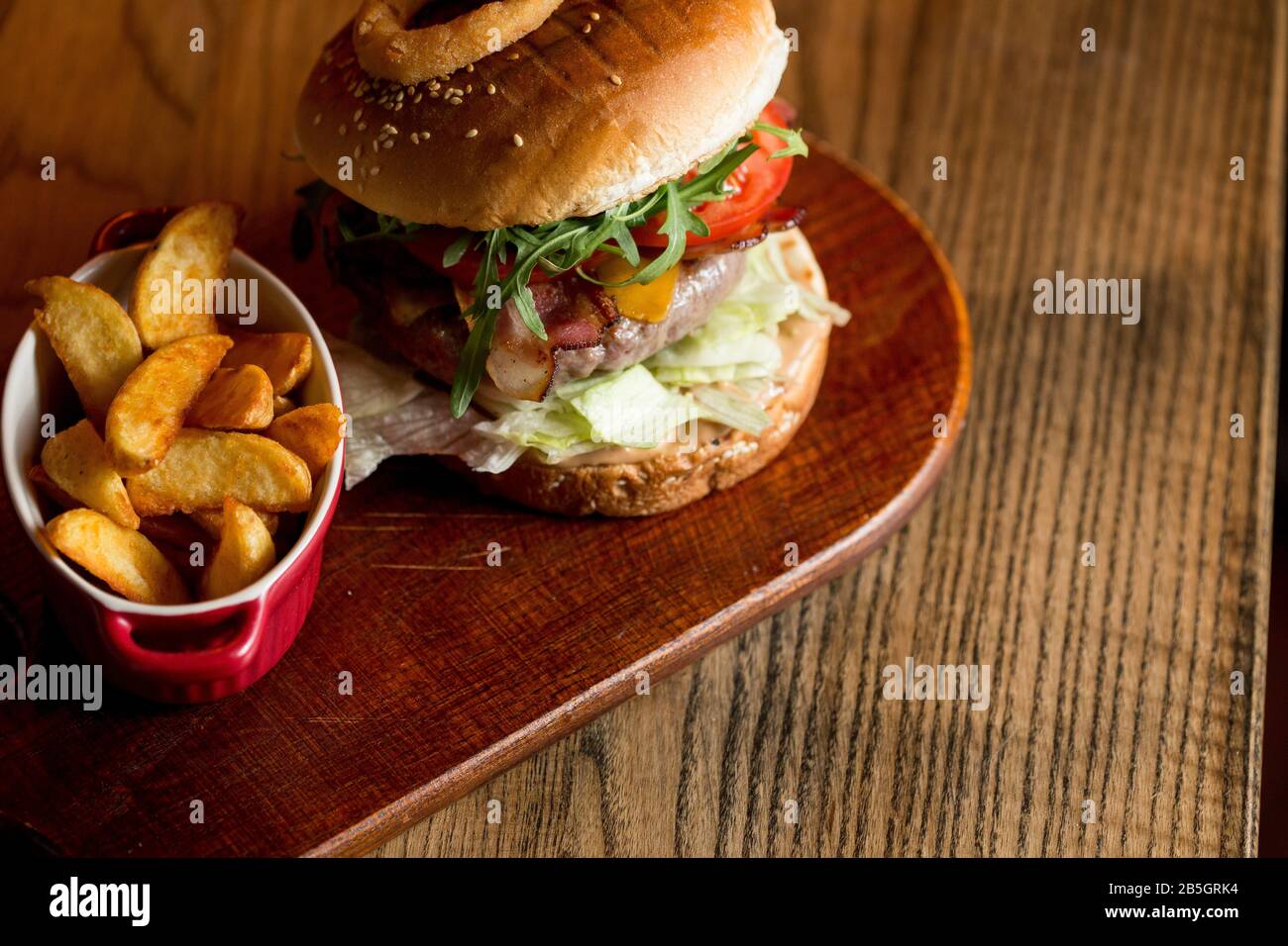Beef burger in homemade pizza dough bun with BBQ sauce, melted chedar ...