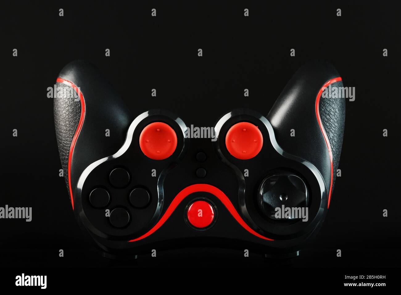 Black game controller gamepad with red buttons on black background ...