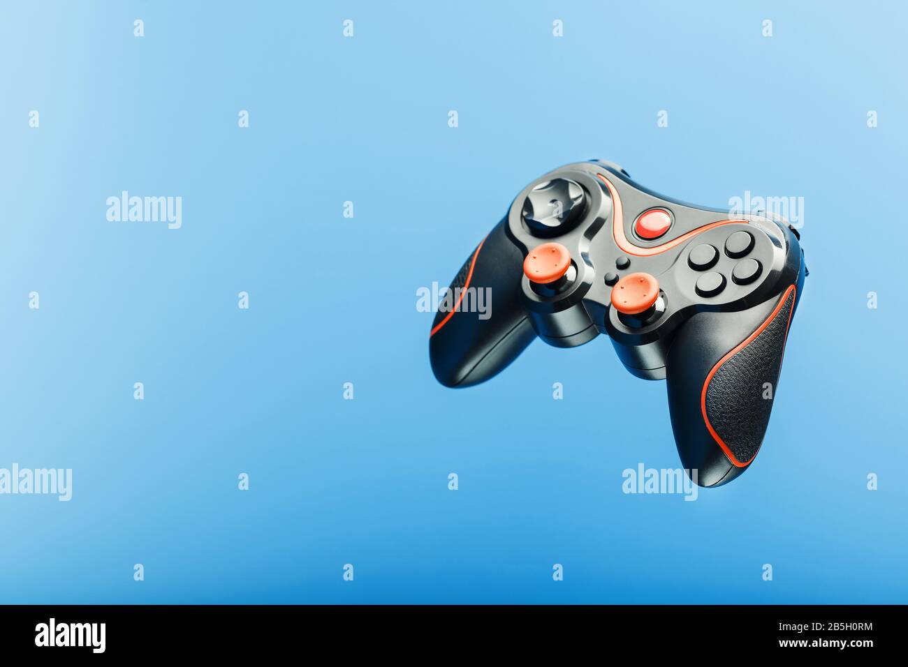 Black gamepad on a black red background, . Gaming concept. Device to ...
