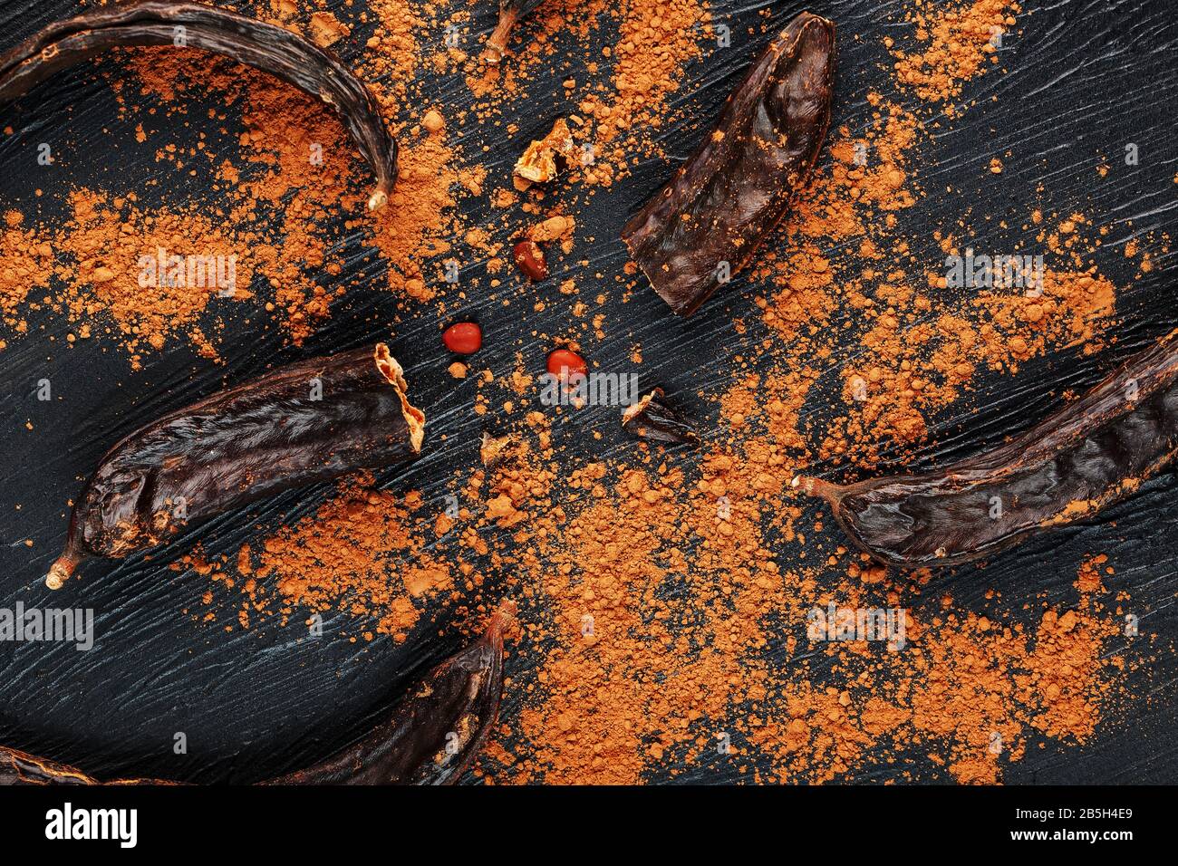 Carob carob fruit with powder on black background. Blast the Sweet ...