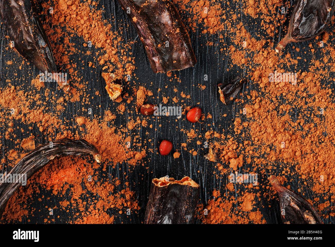 Carob carob fruit with powder on black background. Blast the Sweet ...