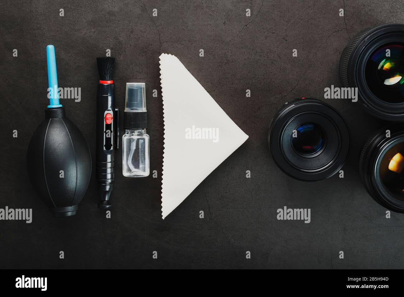 Tools for cleaning the camera with lenses on a dark textured background ...