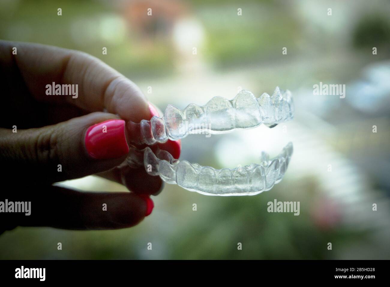 Invisible dental retainer held by womans hand. Copy space Stock Photo ...