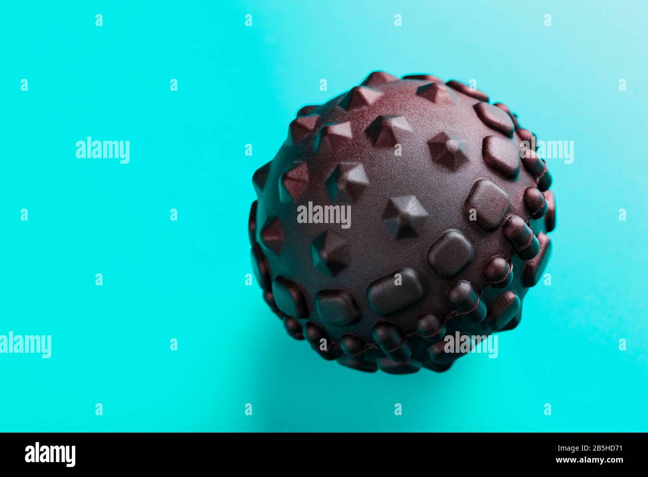 Black bumpy foam massage ball is a rubber ball on a blue background ...