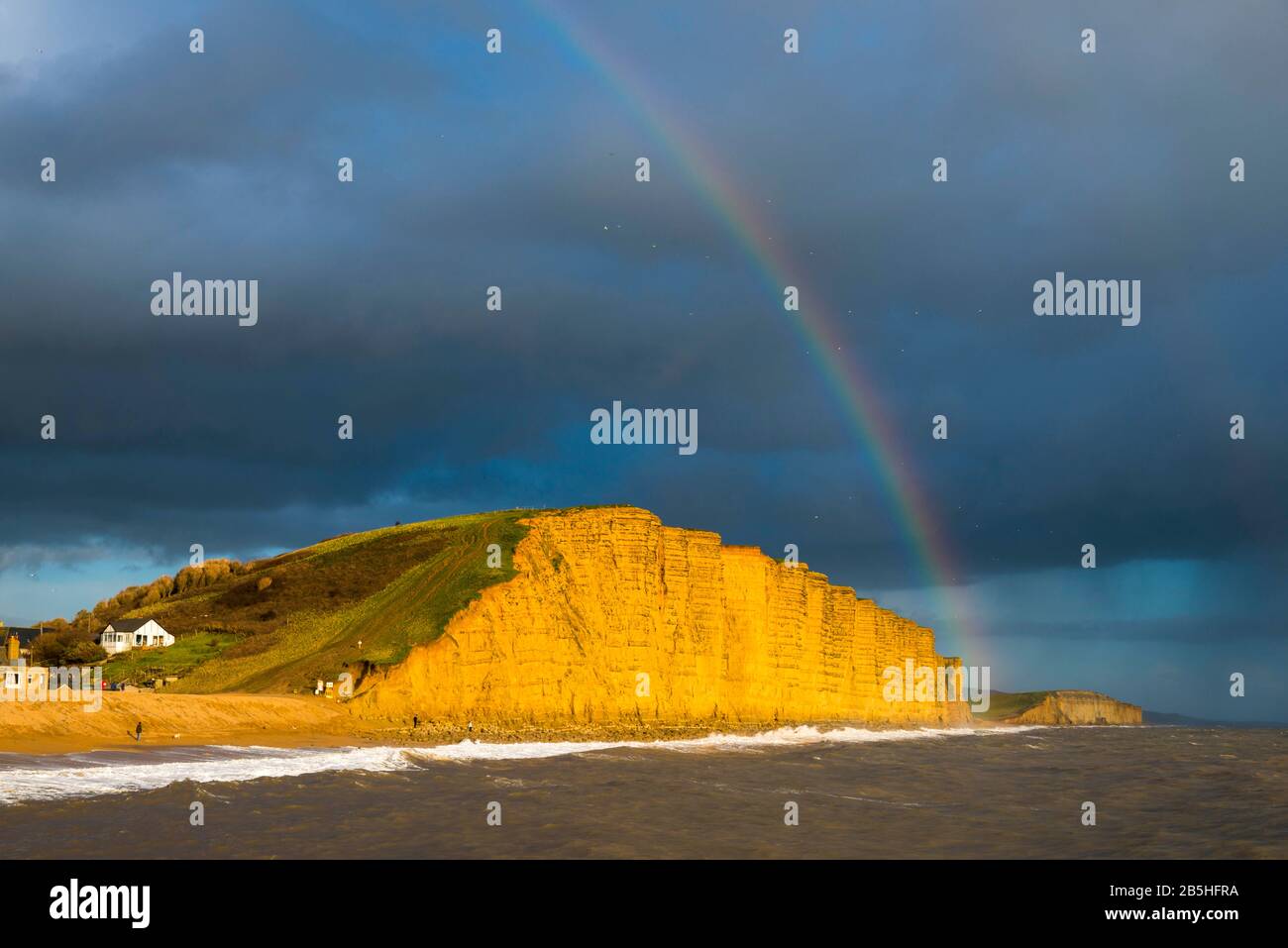 West Bay, Dorset, UK. 8th March 2020. UK Weather. A rainbow arches ...