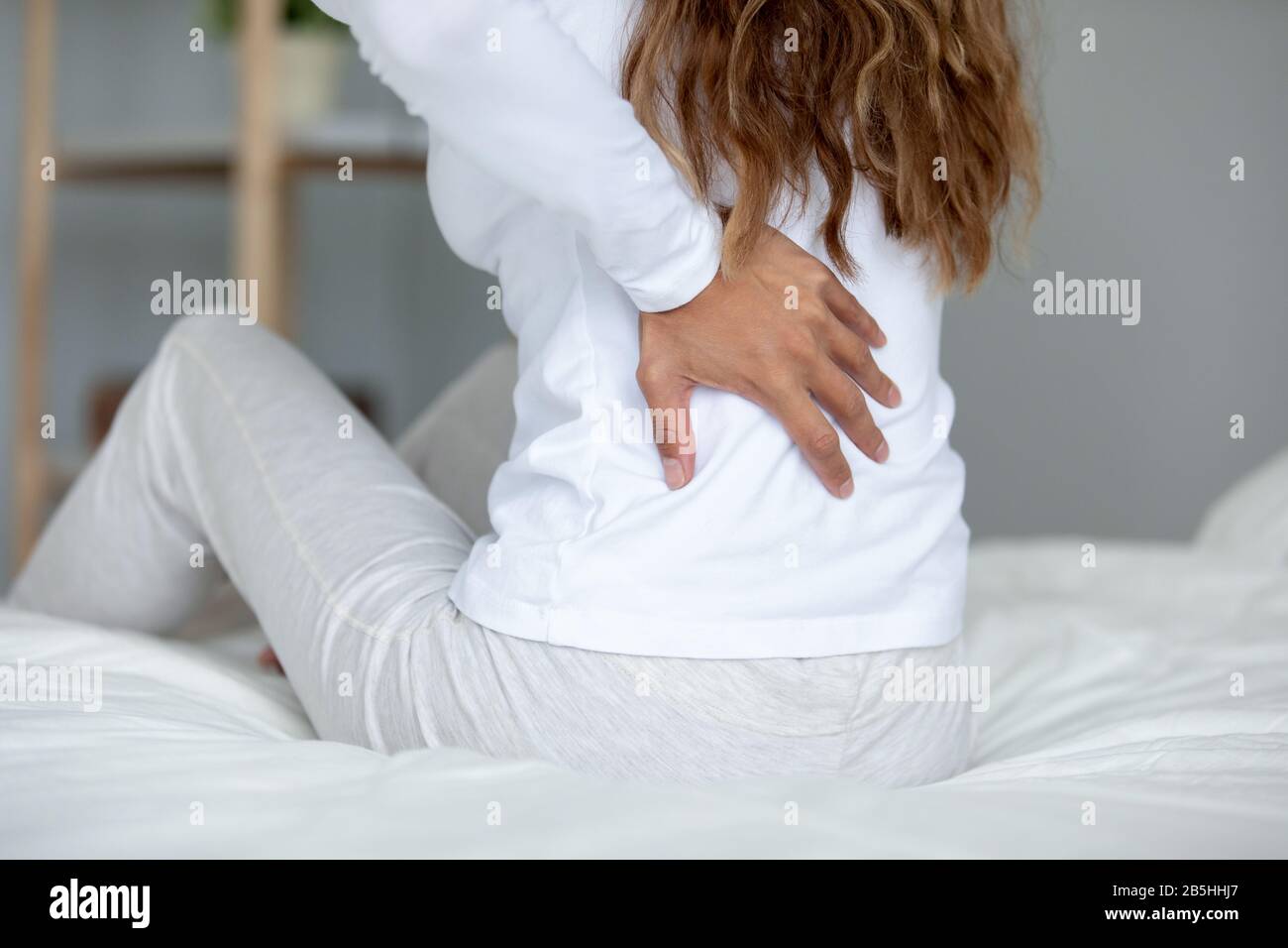 Hurt young woman touch back suffer from spinal pain Stock Photo - Alamy