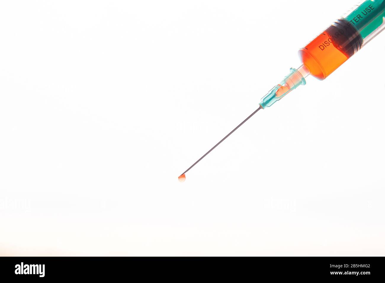 Syringe with a drop of blood at the end of the needle. Medical ...