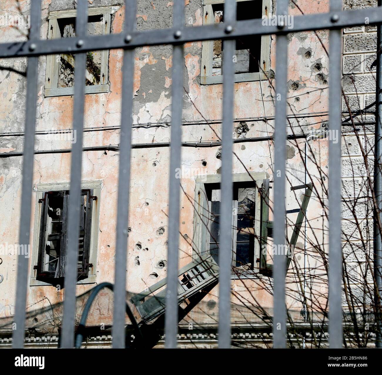 home behind a railing of iron with broken windows by war Stock Photo ...