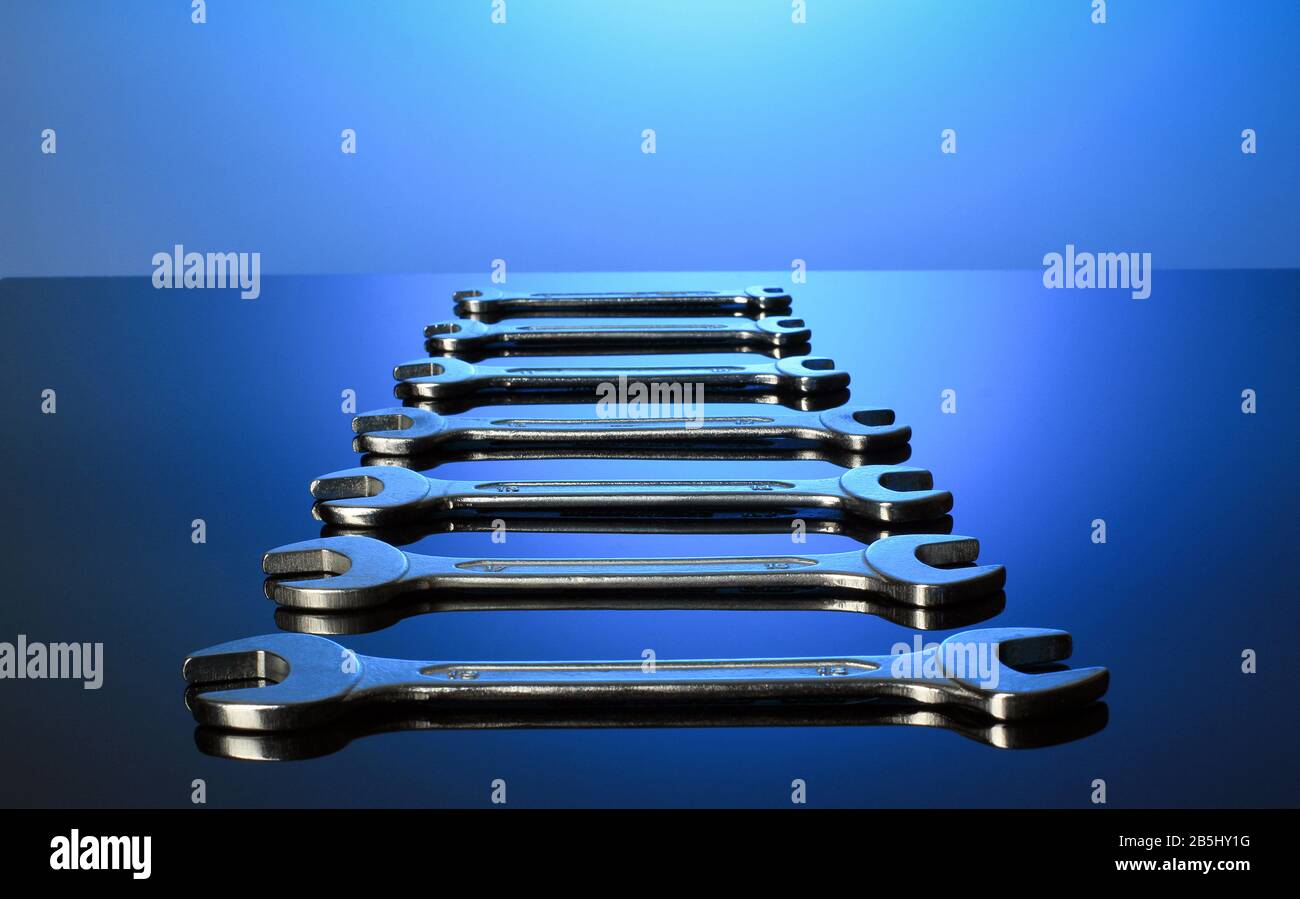 Set of wrenches on a blue background. Mirror surface Stock Photo - Alamy