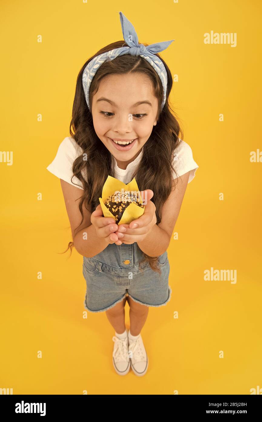Happy childhood. Kid girl hold glazed muffins. Cafe restaurant food ...