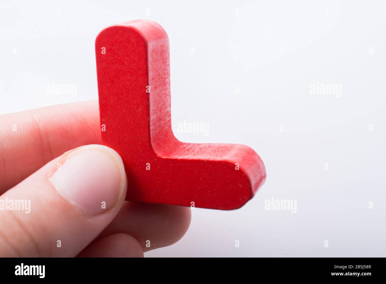Hand holding letter cube L of made of wood Stock Photo - Alamy