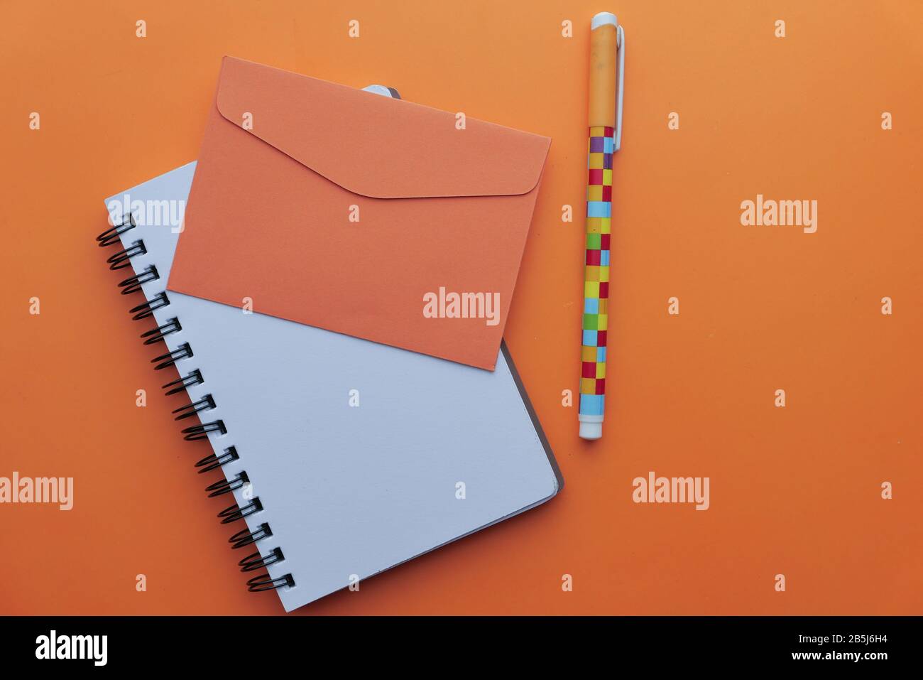 orange color envelope, pen and notepad Stock Photo - Alamy