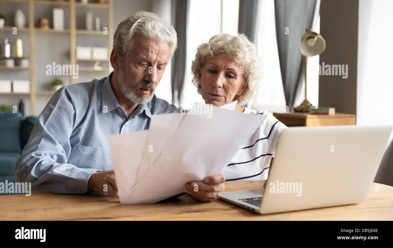 Elderly husband and wife read documents pay bills online Stock Photo ... Elderly husband and wife read documents pay bills online Stock Photo ...