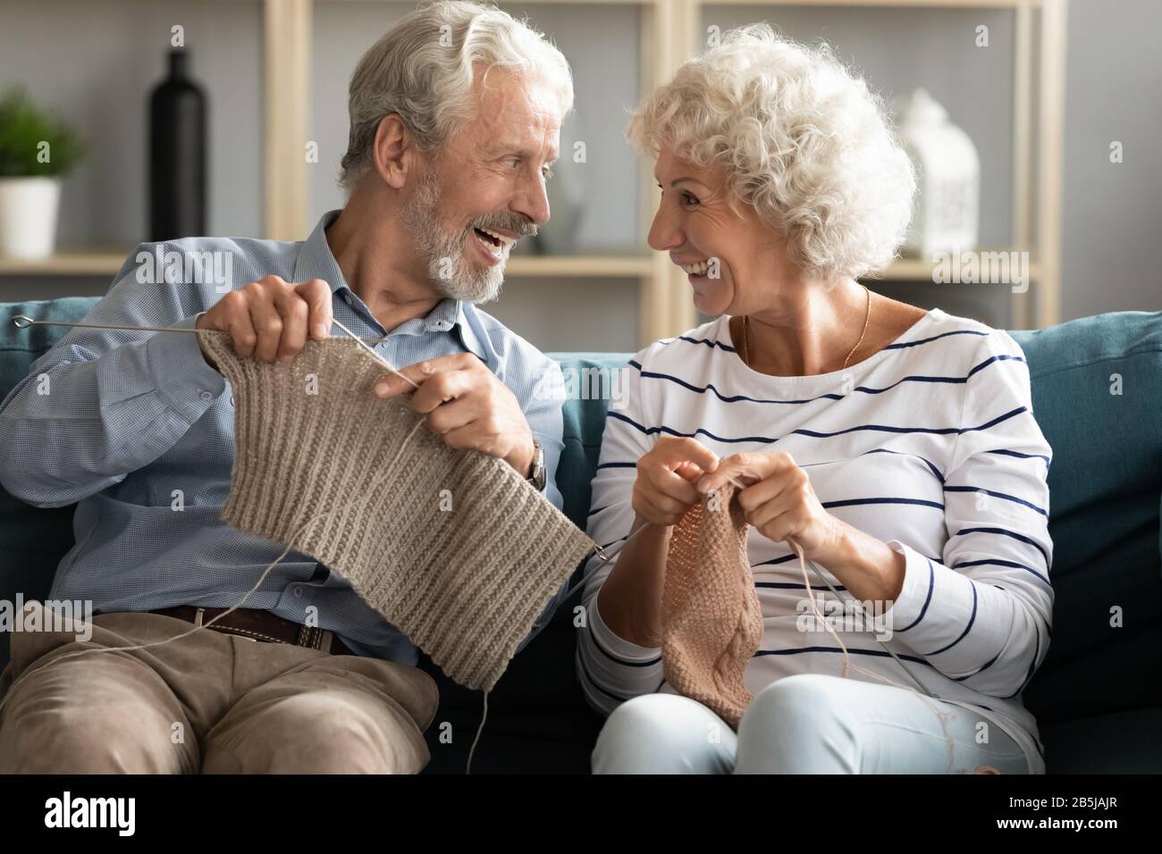 Overjoyed elderly couple have fun knitting at home together Stock Photo ... Overjoyed elderly couple have fun knitting at home together Stock Photo ...