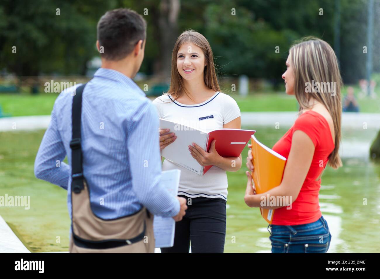 Group of students talking at the park Stock Photo - Alamy
