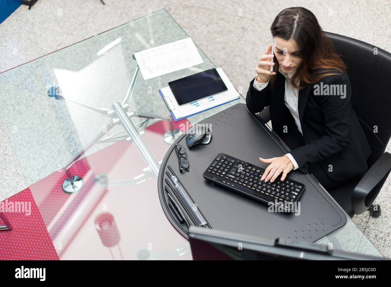 Smiling secretary talking at the phone Stock Photo - Alamy