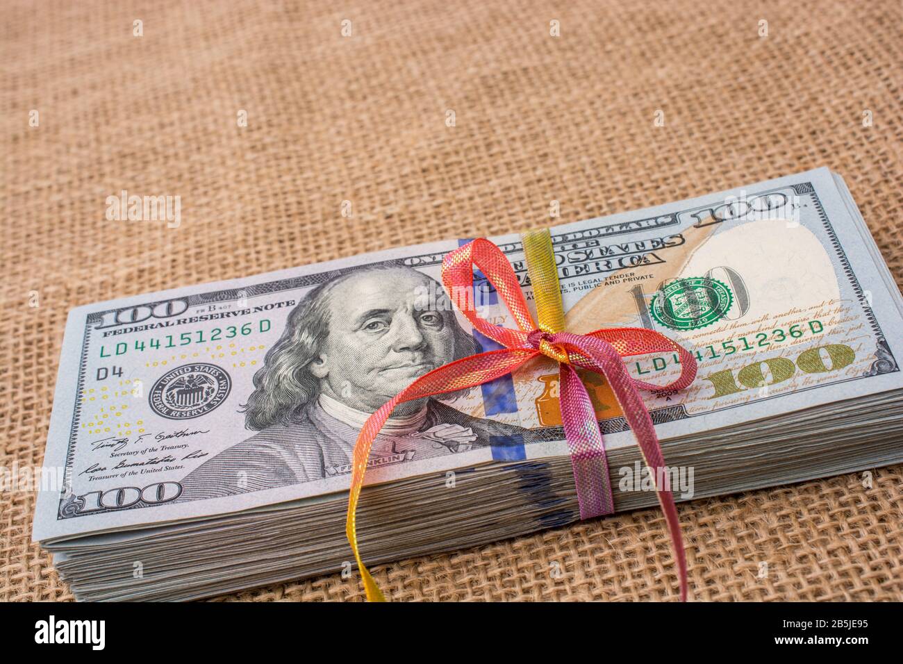 Banknote bundle of US dollar tied with colorful a ribbon Stock Photo ...