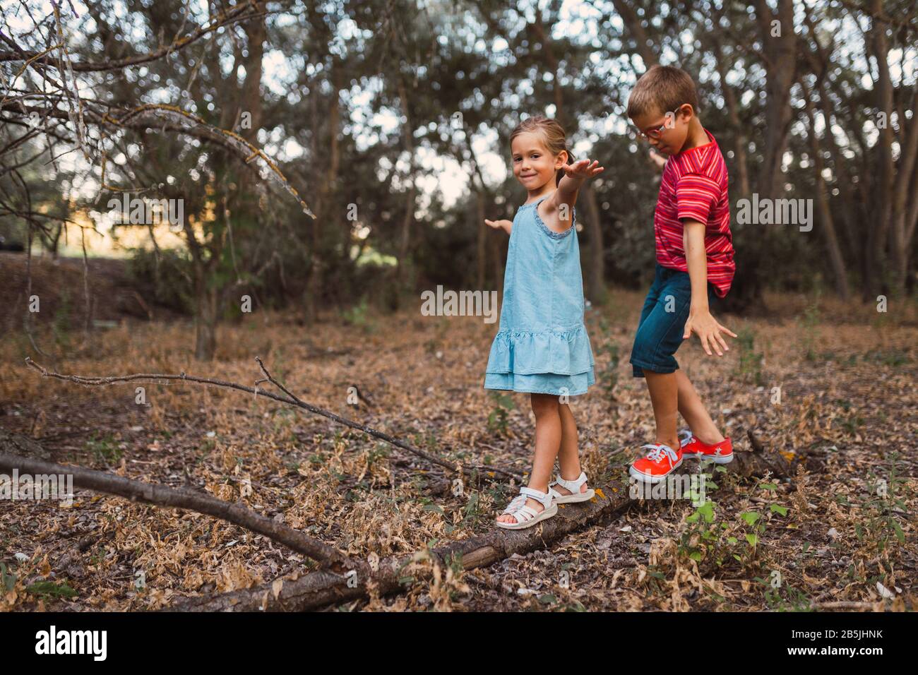 Two kids playing in the forest Stock Photo - Alamy
