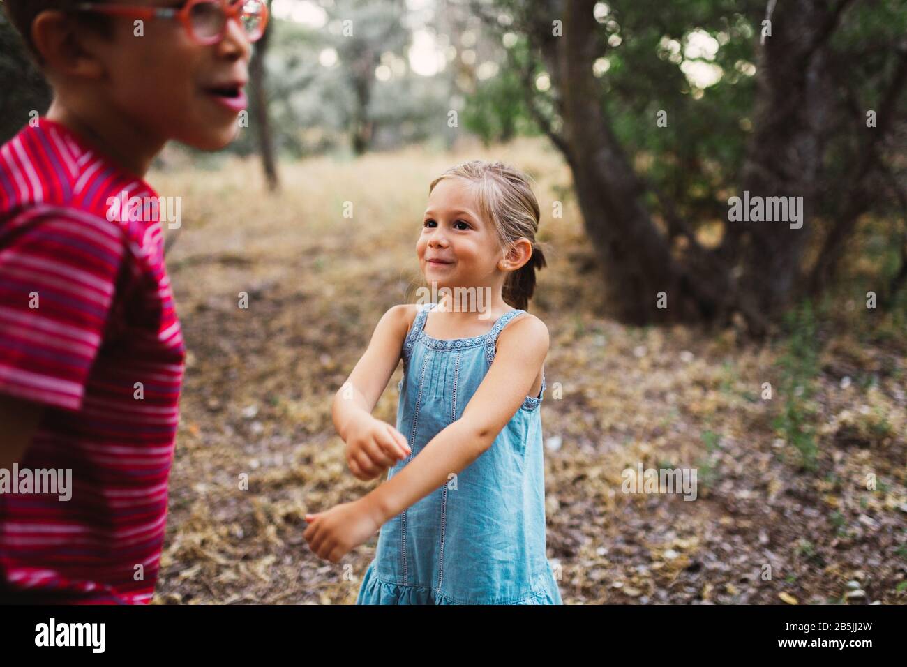 Two kids playing and dancing in the forest Stock Photo - Alamy