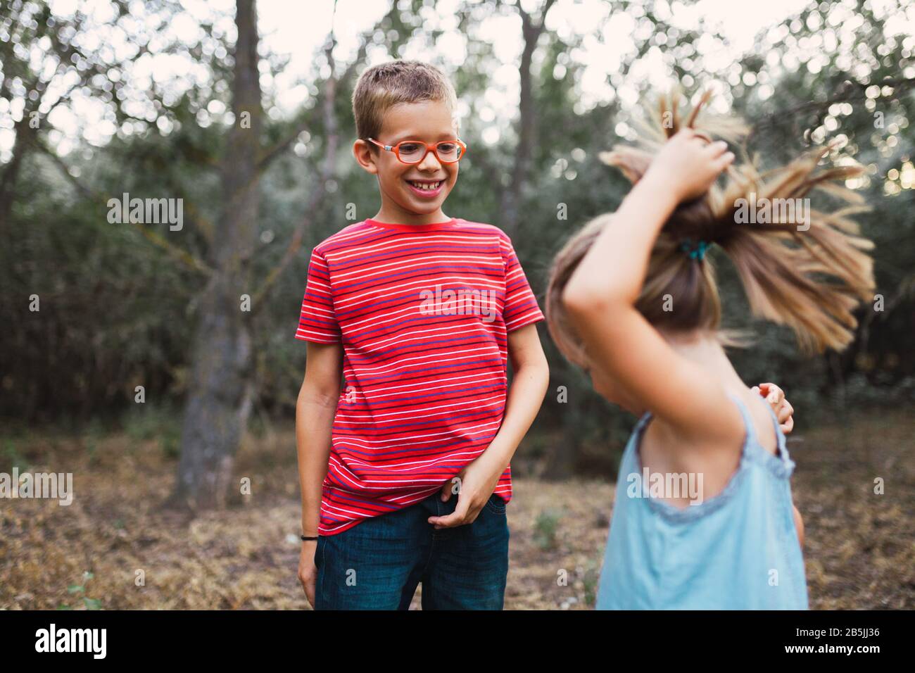 Two kids playing and dancing in the forest Stock Photo - Alamy