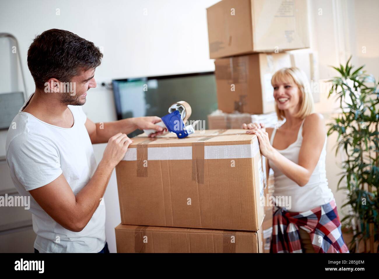 young couple packing things for moving. moving, new beginning, concept ...