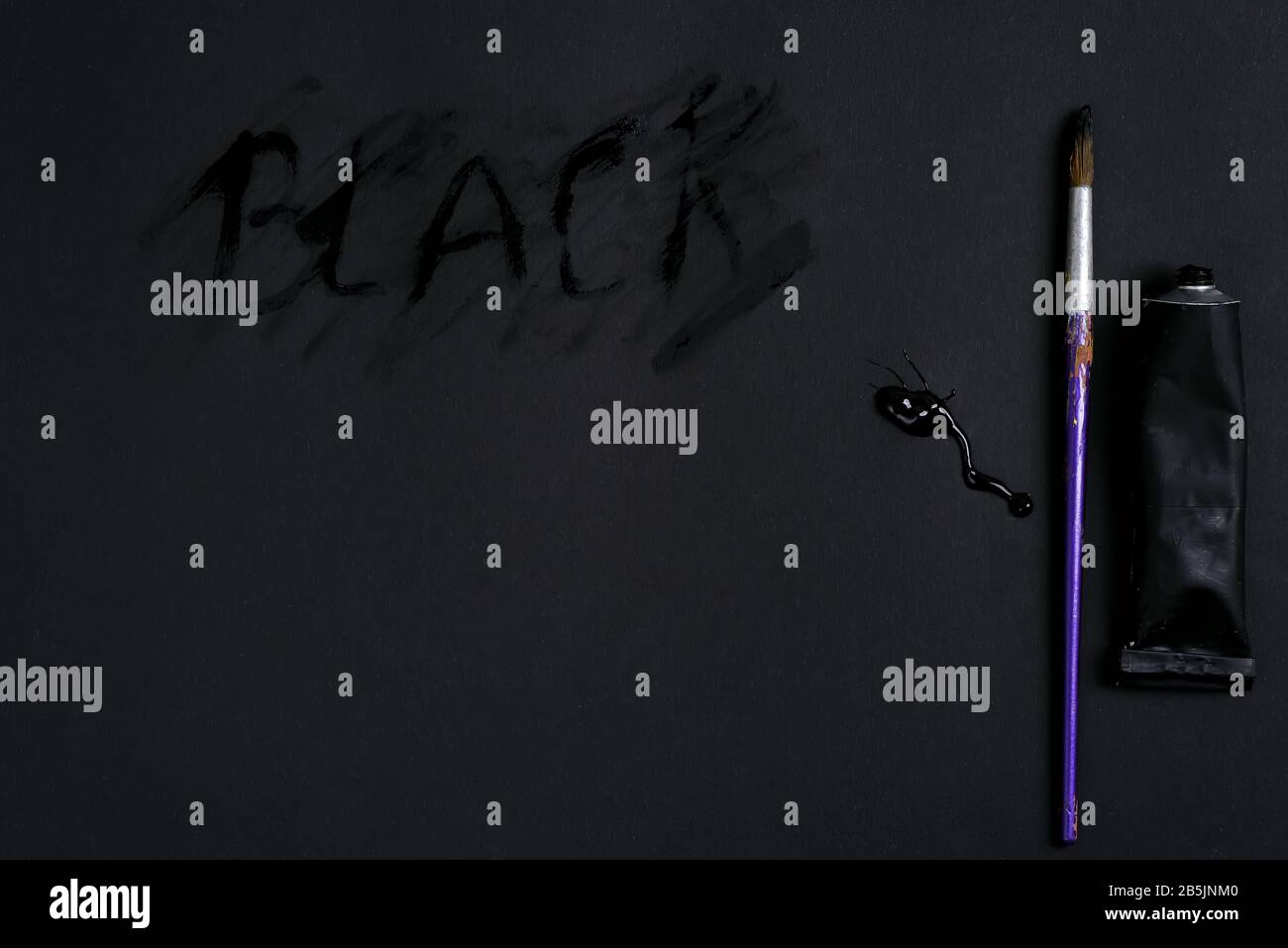 Art set from tube, black paint squeezed and text Black handwritten by ...