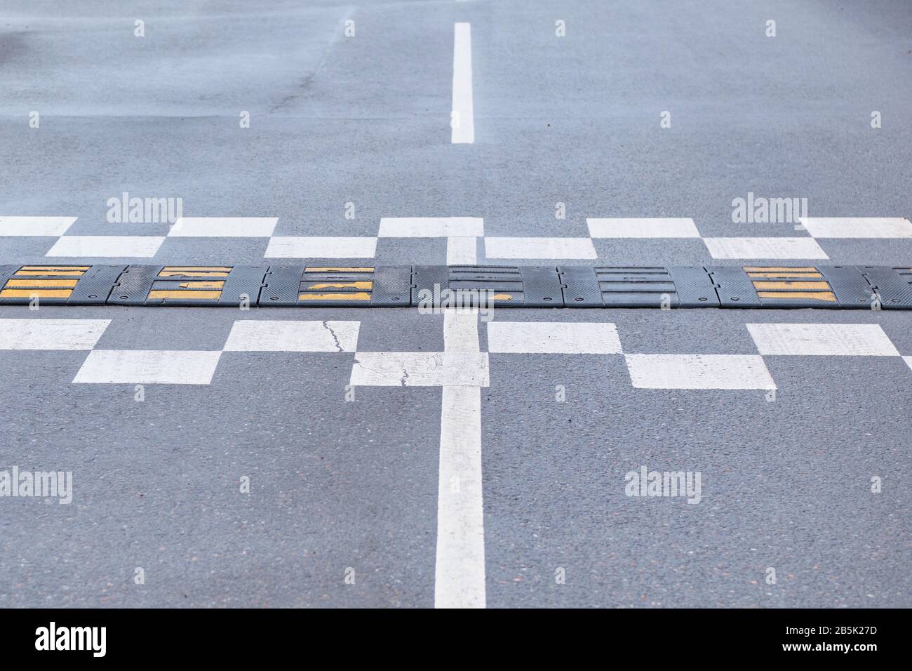 Speed bump on the pavement. Close up Stock Photo - Alamy