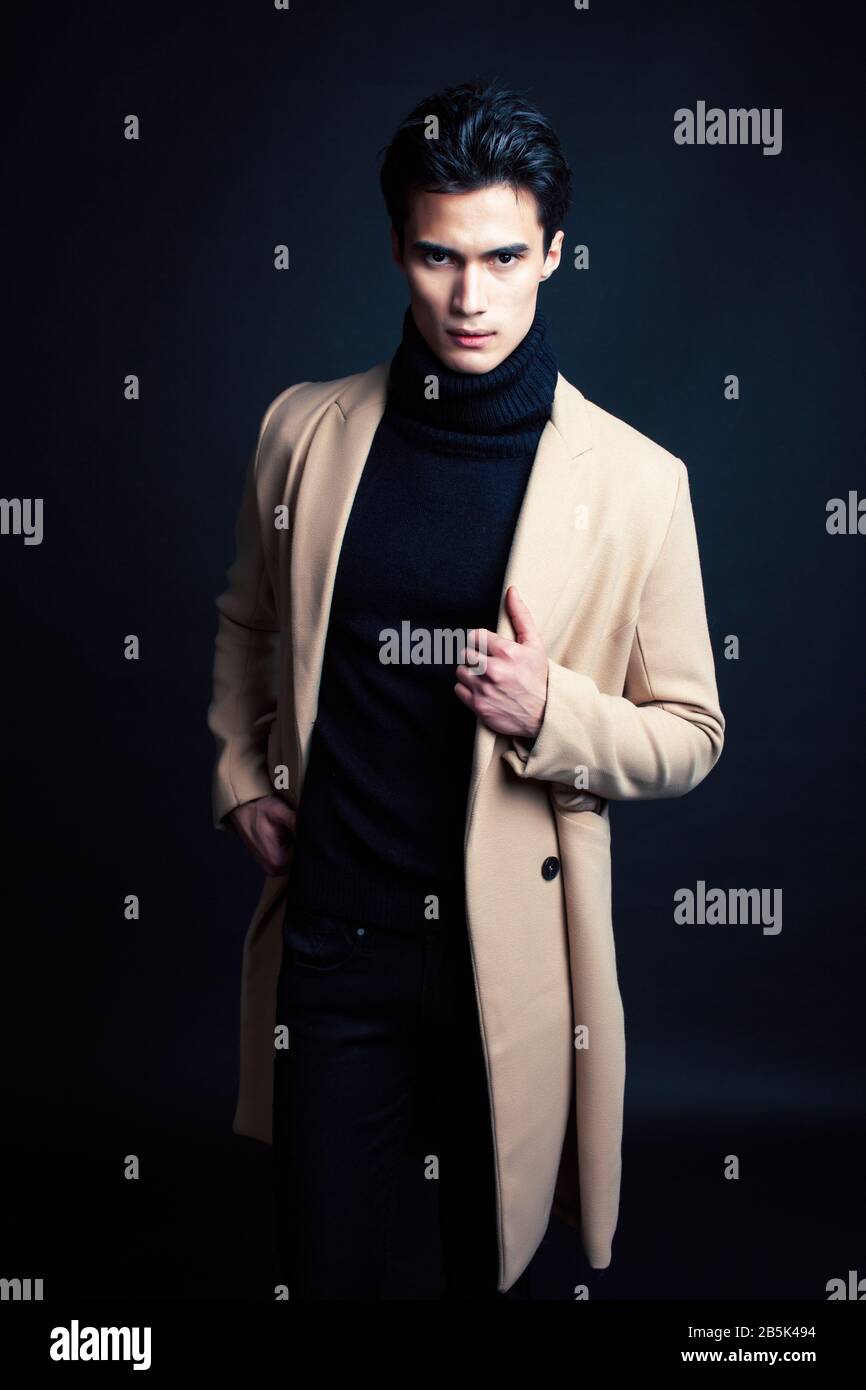 handsome asian fashion looking man posing in studio on black background ...