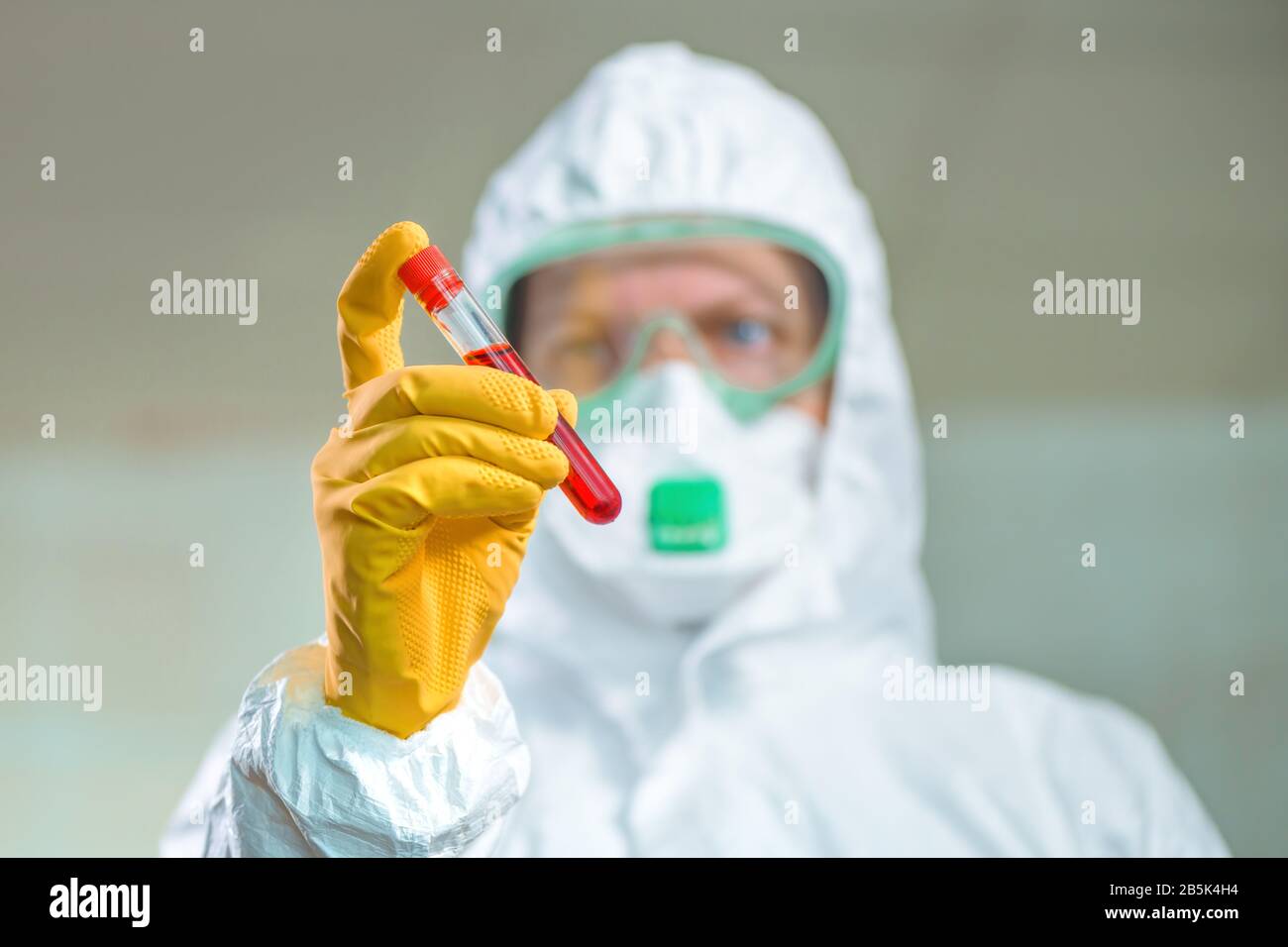 Epidemiologist examining medical sample test tube in virus quarantine ...