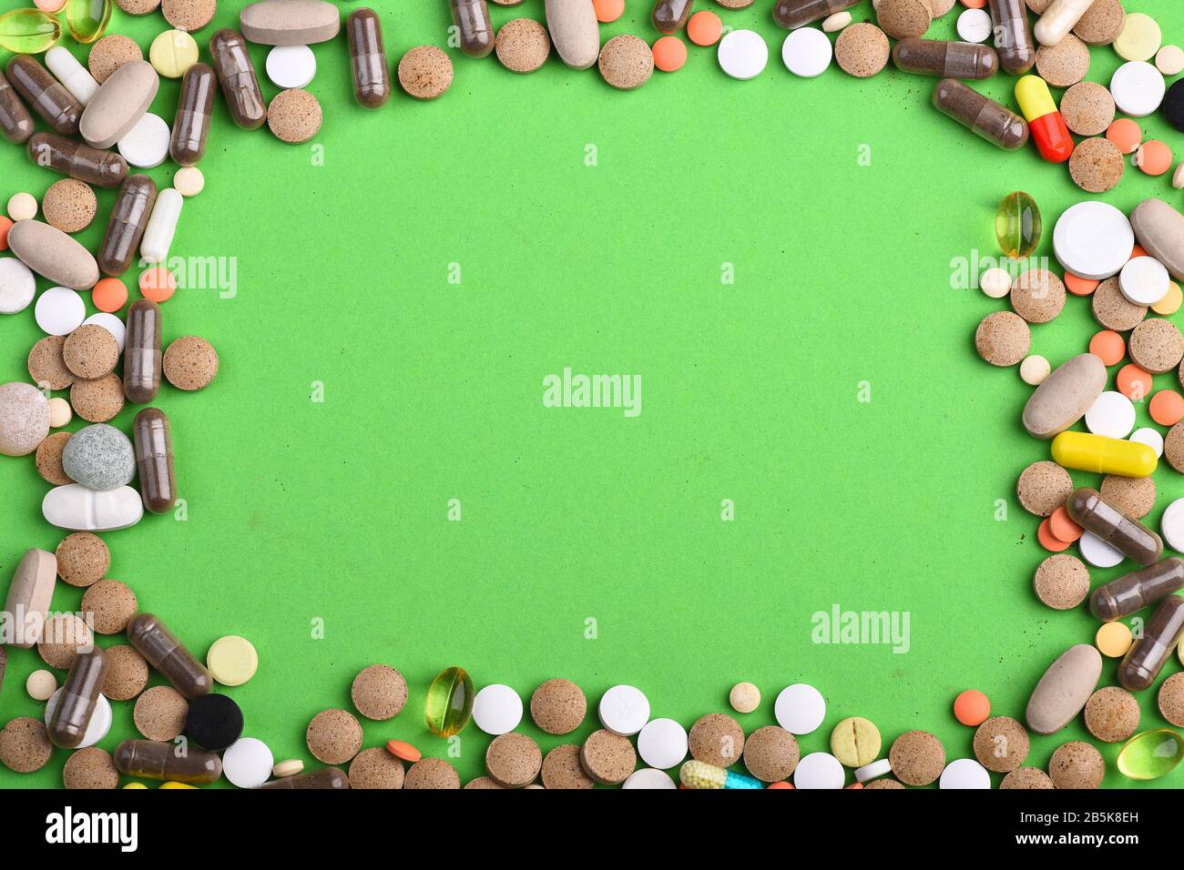 Frame border from colorful medicine capsules on green background ...
