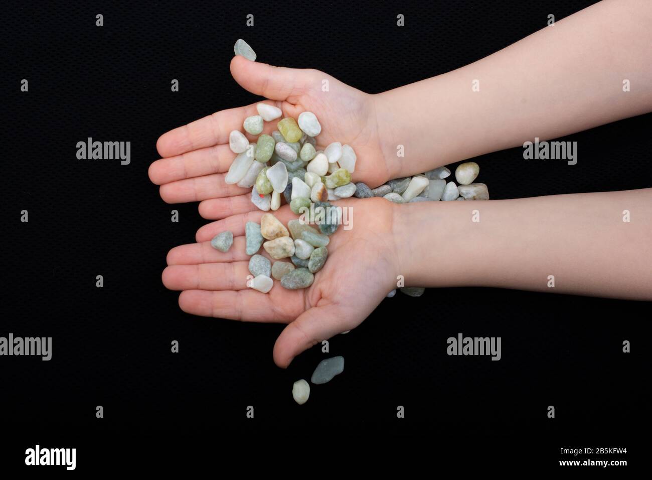 Handful of clean pebbles, gravels in hands Stock Photo - Alamy