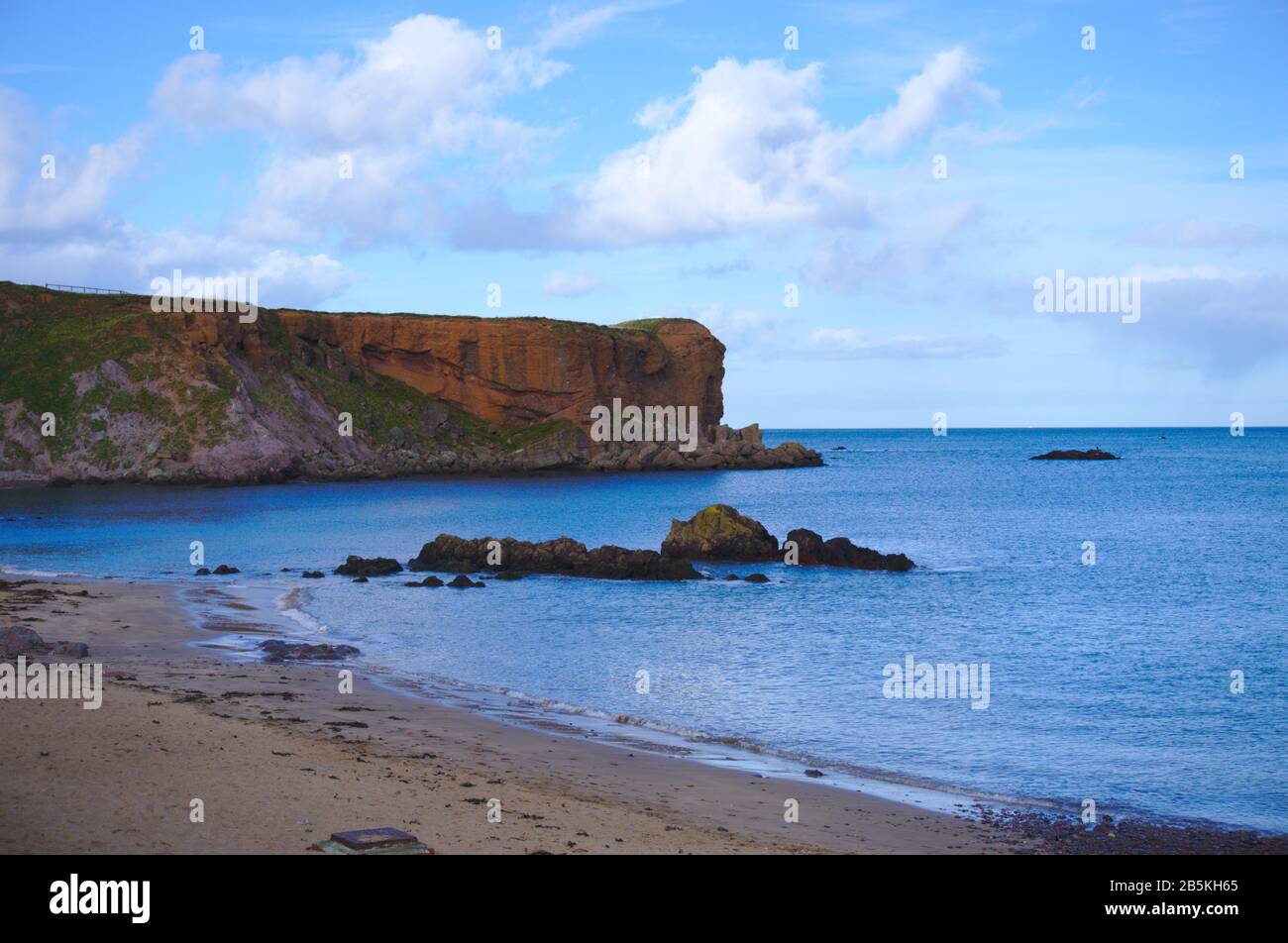 Red stone cliffs at the north end of the bay looking out towards the ...