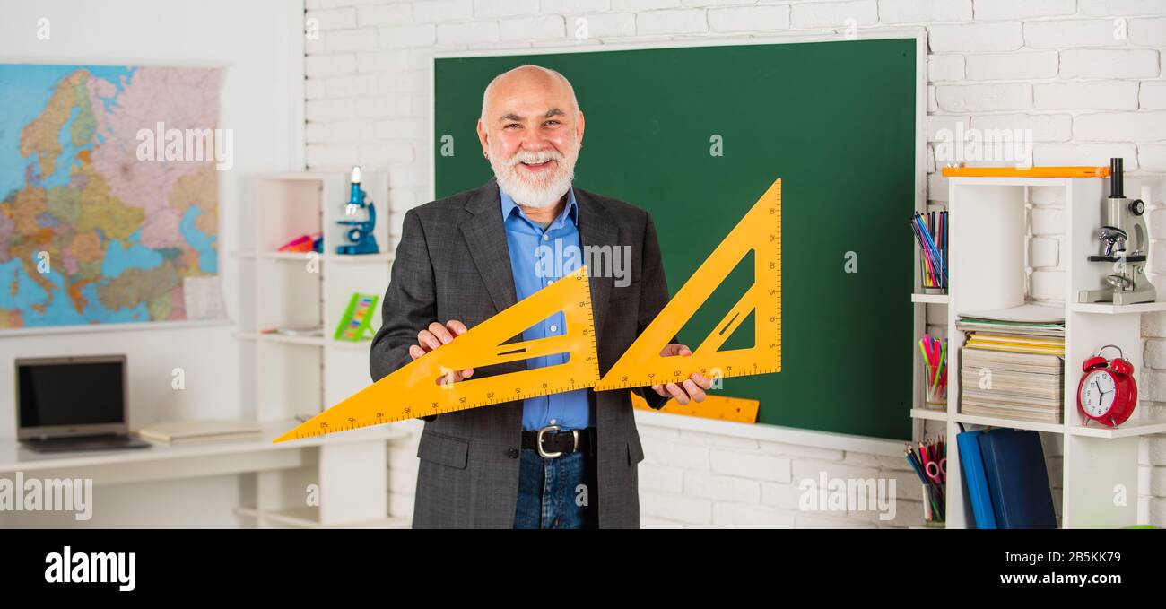 solve mathematical problems. mature man teacher use math triangle tool ...