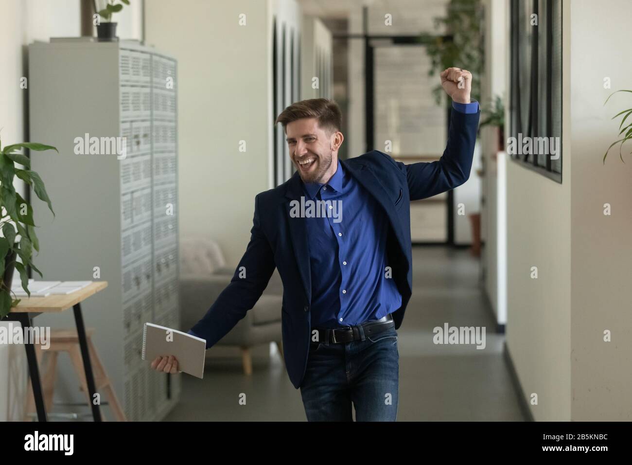Happy male employee have fun in office celebrating success Stock Photo ...