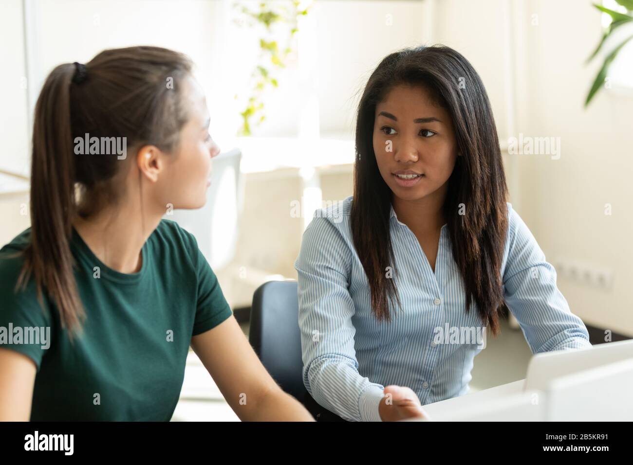 Multiracial female colleagues talk cooperating at office meeting Stock ...