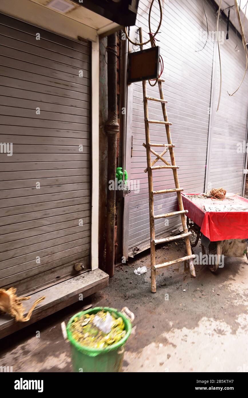 Bamboo ladder up against the shop shutter Stock Photo - Alamy