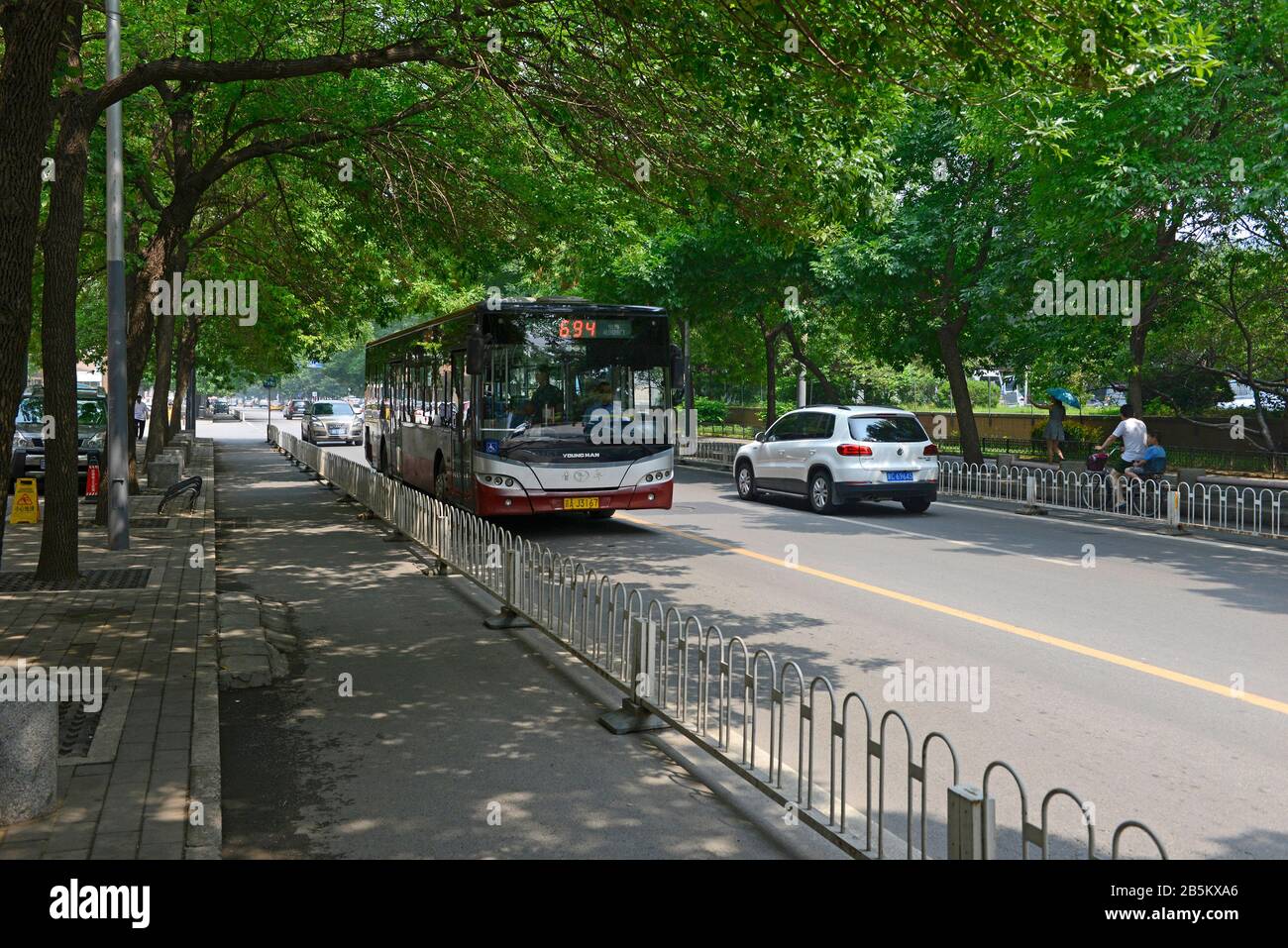 A bus travels along a tree lined street in the Asian Games village ...